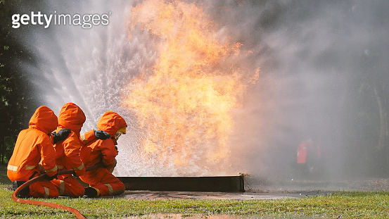 Firefighter fighting with flame using fire hose chemical water foam ...