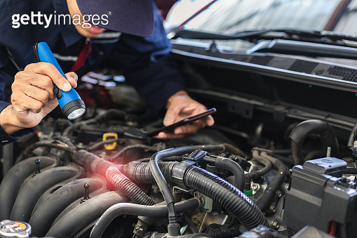 Asian Man mechanic inspection Shine a torch car engine checking bug in ...