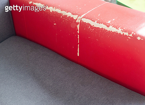 Torn and battered leather back of the sofa. Poor quality leather ...