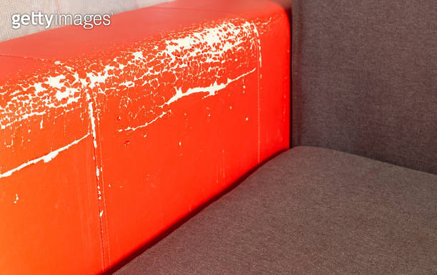 Torn and battered leather back of the sofa. Poor quality leather ...