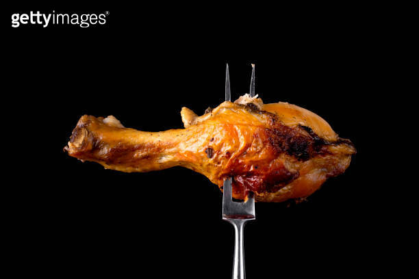 Roasted chicken legs on a meat fork isolated on a black background. 이미지 ...