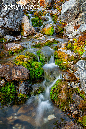 Beautiful little stream forms mini waterfalls as it goes through rocks ...