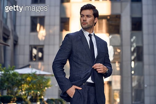 Young and successful. Handsome young man in full suit posing while ...