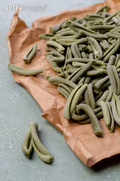 Green dry pasta on parchment paper 이미지 (1290803991) - 게티이미지뱅크