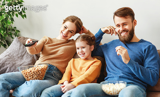Happy family resting with snacks on couch at home 이미지 (1241650826) - 게티 ...