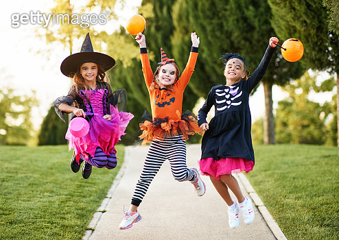 Happy girls in Halloween costumes jumping on path 이미지 (1272946500) - 게티 ...