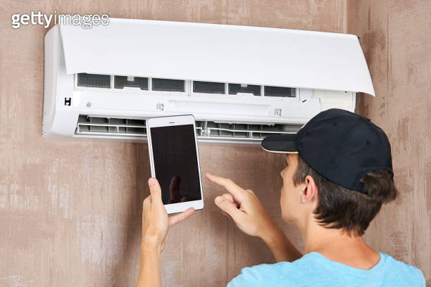 male technician service worker diagnosing for repairs air conditioner ...