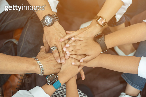 Hands working together in the room with parents and children doing ...