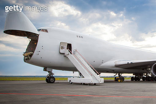 Unloading widebody cargo aircraft at the airport apron. Freight ...