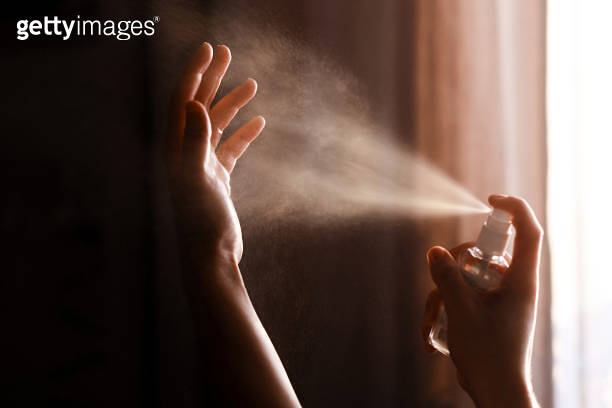 Disinfecting hands. Person using antiseptic spray on hands to prevent ...