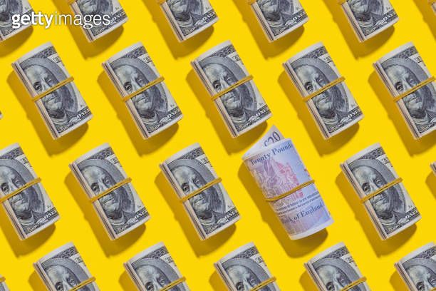 British pound and American dollar rolls on yellow background 이미지 ...