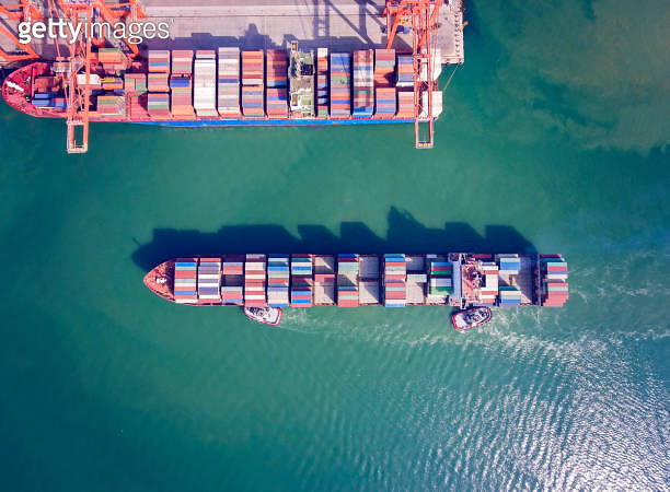 Aerial View of One Cargo Ship Arriving and one leaving in Port ...