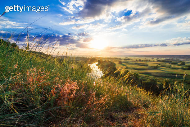 A beautiful valley with a river, blue sky with large clouds and bright ...