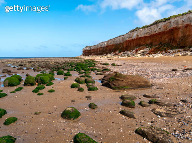 Hunstanton beach with rock formations and striped cliffs 이미지 ...
