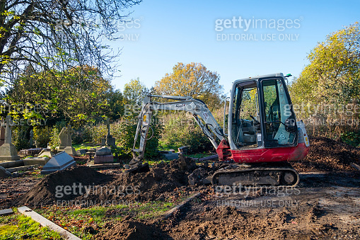 Mechanical digger working in a cemetery 이미지 (1291981979) - 게티이미지뱅크