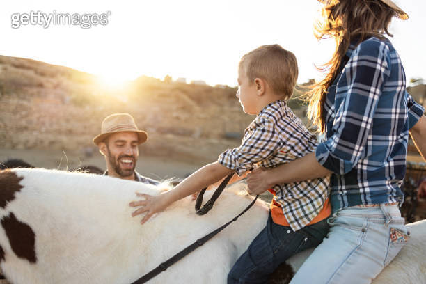 Happy parents with little son riding a horse at farm ranch - Family ...
