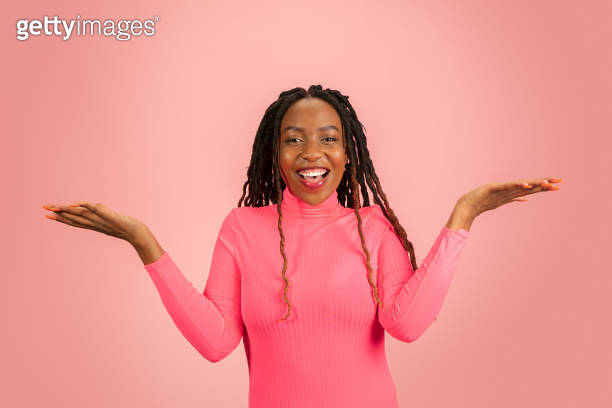 Happy emotional african-american woman isolated on pink studio ...