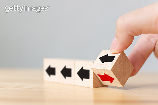 Hand flip over wooden cube block with red arrow facing the opposite ...