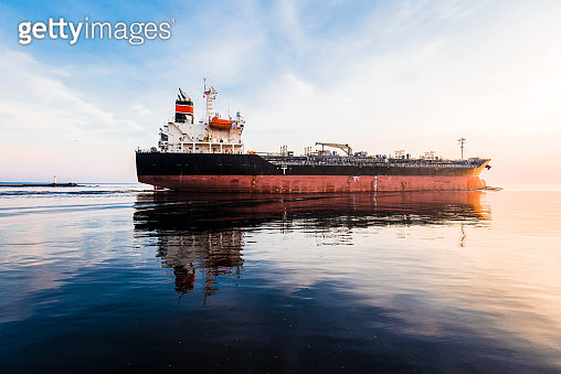 Large cargo ship at sunset. Colorful evening clouds and bright sunlight ...