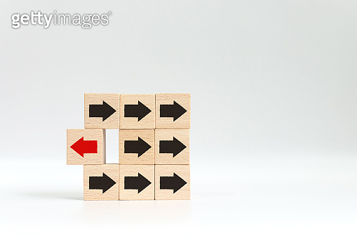 Wooden block with red arrow facing the opposite direction black arrows ...