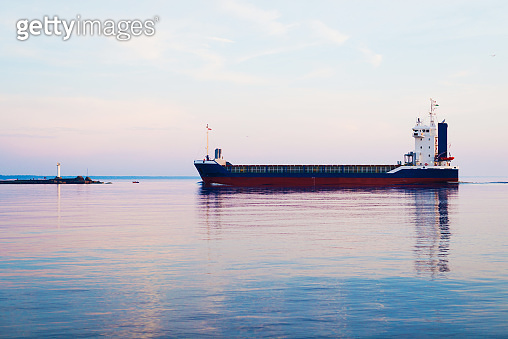 Large cargo ship at sunset. Colorful evening clouds and bright sunlight ...