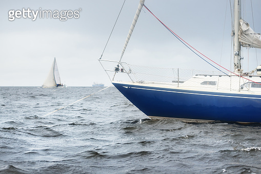 Blue sloop rigged yacht anchored off the coast of England under the ...