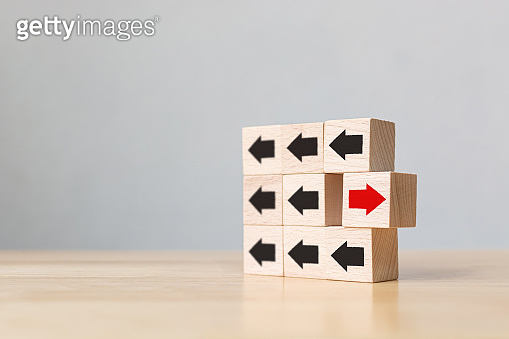 Wooden block with red arrow facing the opposite direction black arrows ...