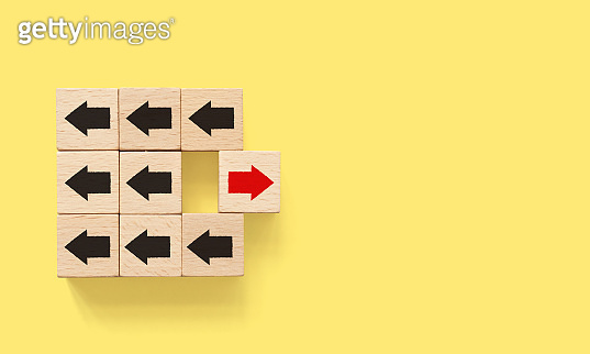 Wooden block with red arrow facing the opposite direction black arrows ...
