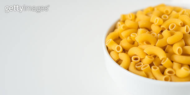 Raw dry uncooked Elbow Macaroni pasta spaghetti on white background ...