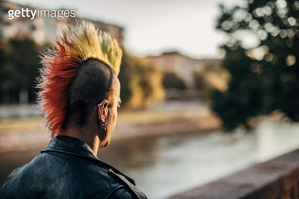 Male punk person with dyed Mohawk standing on the street in city 이미지 ...