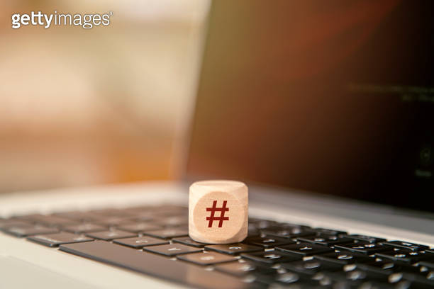 Hashtag written on wooden cube on a laptop computer keyboard. 이미지 ...