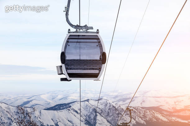 Cabin of a gondola cableway suspended on a rope where sits people with ...