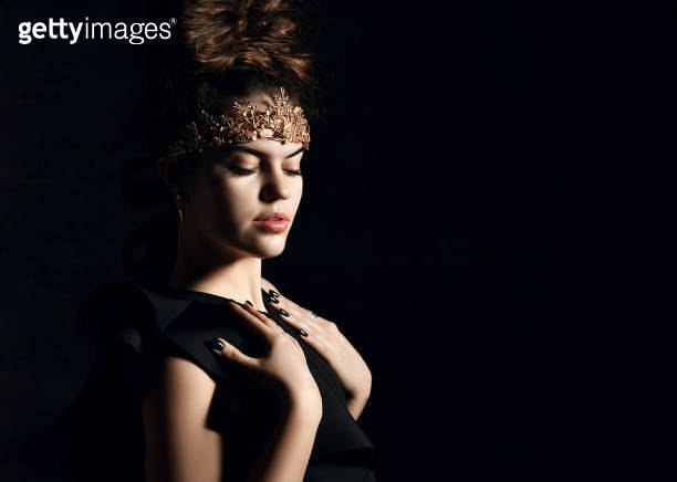 Attractive brunette woman with golden tiara crown on her forehead beam ...