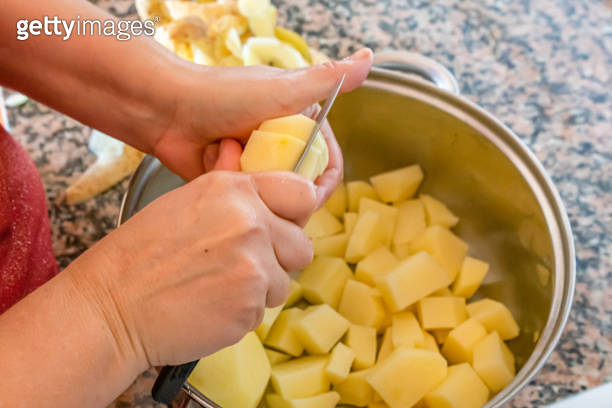 Woman hands cutting potatoes into chunks to prepare food 이미지 ...