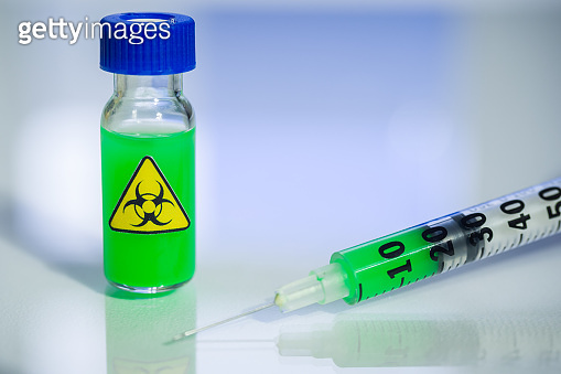 biologically dangerous substance in a syringe and a test tube on a ...