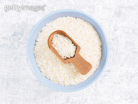 Indian long grain Basmati rice in blue ceramic bowl and wooden scoop on ...