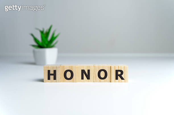 The word Honor written in vintage wooden cubes on a white background ...