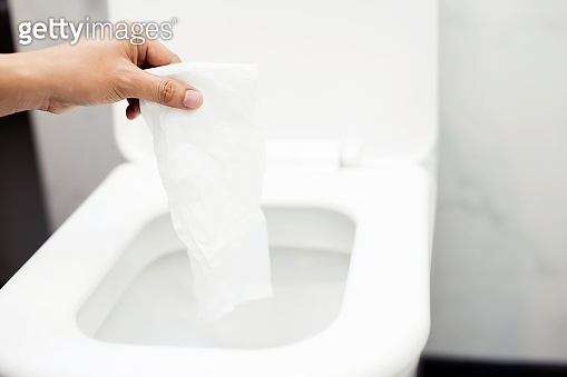 closeup of a young man throwing a wet wipe to the toilet 이미지 ...
