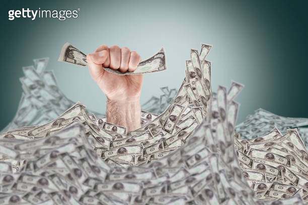 A man's hand clenched in a fist a banknote peeking out from a large ...