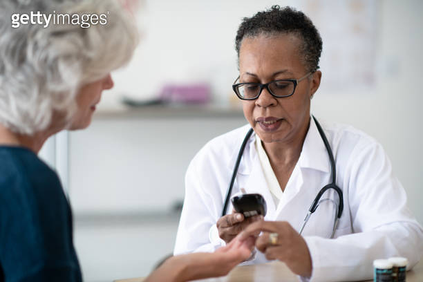 Doctor Teaching Her Patient How To Test Her Blood Sugar stock photo 이미지 ...