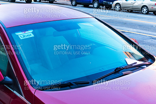 Lyft and Uber emblem stickers under car windshield. Parking ticket ...