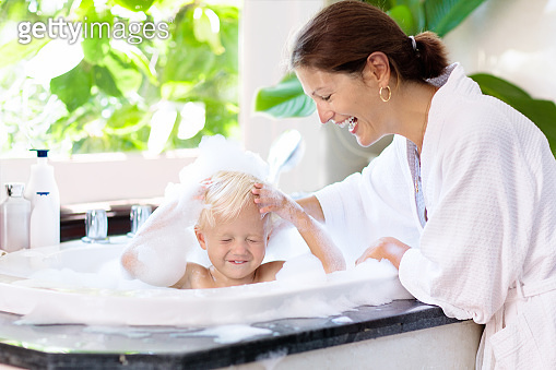 Mother washing baby in bubble bath. Water fun. (1207221484) - 게티이미지뱅크