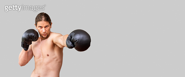 Athlete muscular handsome man posing punching with boxing gloves on ...