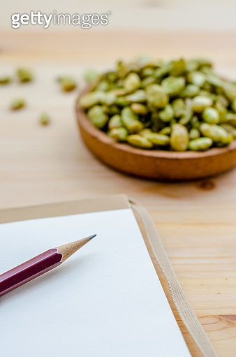 Pencil paper note and edible seeds of hyacinth bean snack for relax ...