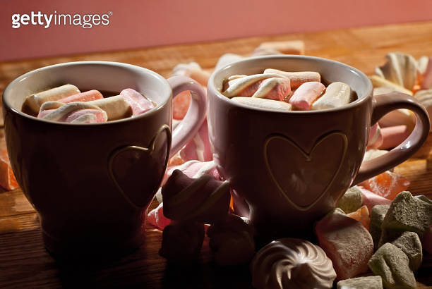 Lots of sweets near coffee mugs. Mugs on a pink background. The ...