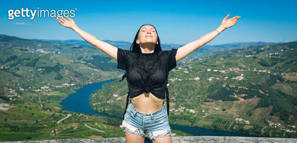 Woman enjoy freedom traveling and open her arms for embrace the nature ...