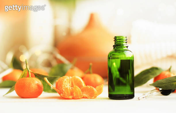 Tangerine essential oil, green glass bottle with aromatic fruit essence ...