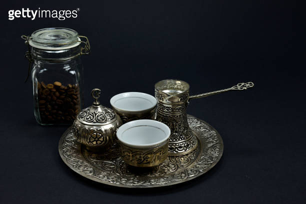 Traditional Arabic coffee set with a jar full of roasted coffee beans ...