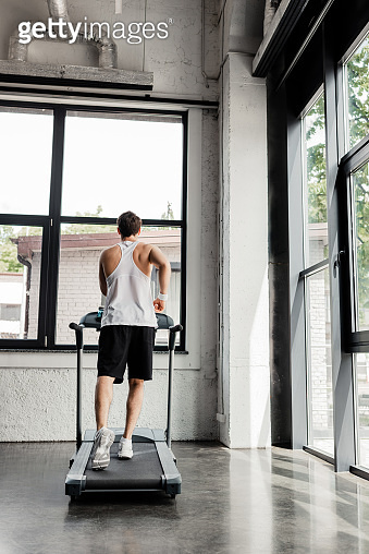 back view of sportsman running on treadmill in gym (1255387045) - 게티이미지뱅크