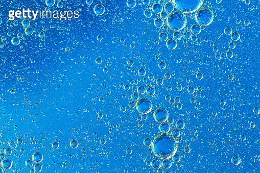 Macro Oxygen bubbles in water on a blue background, concept such as ...